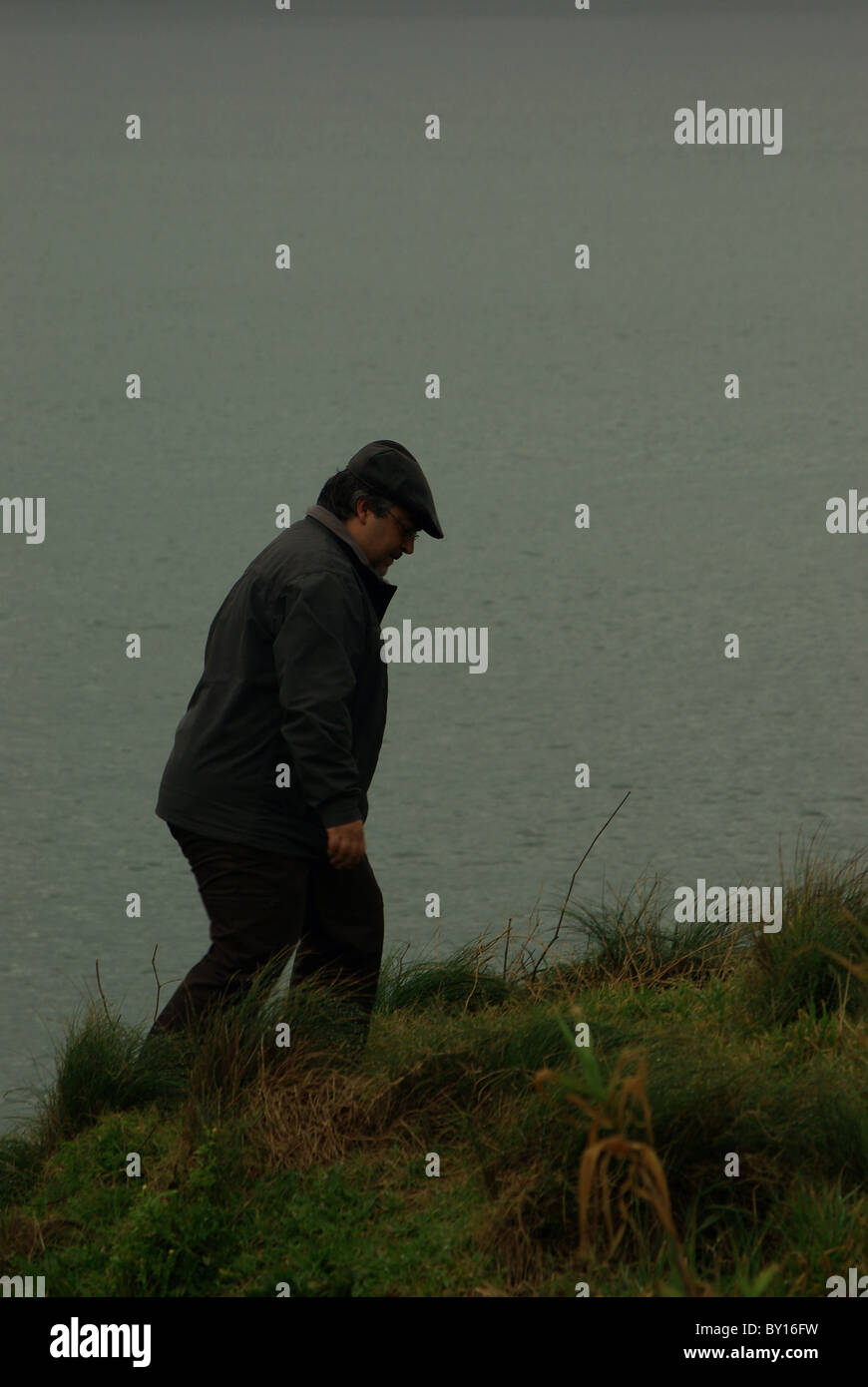 man walking on a nature Azorean trail during early mist/fog on the ...