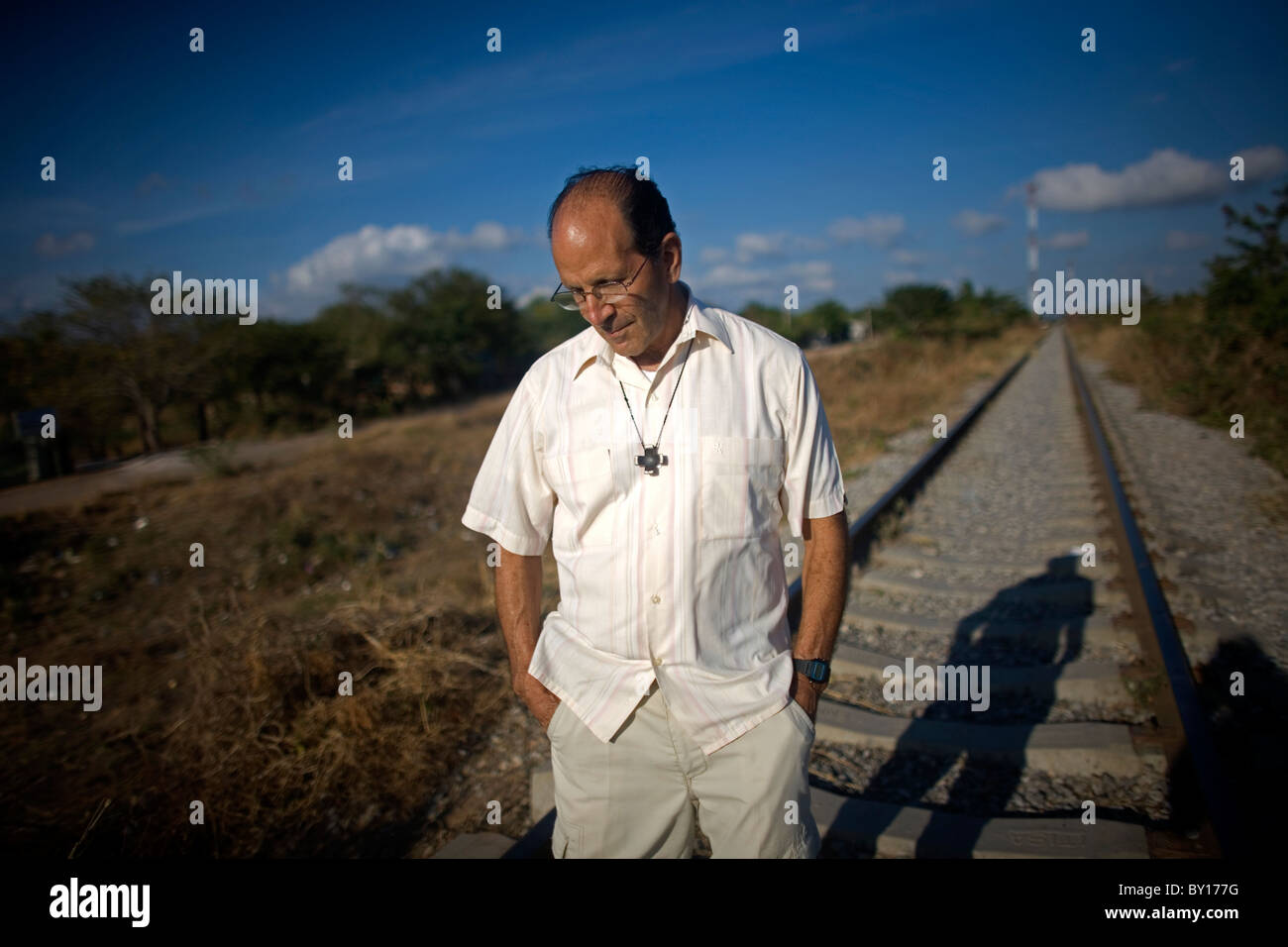 Catholic priest Alejandro Solalinde walks in the railway line in ...