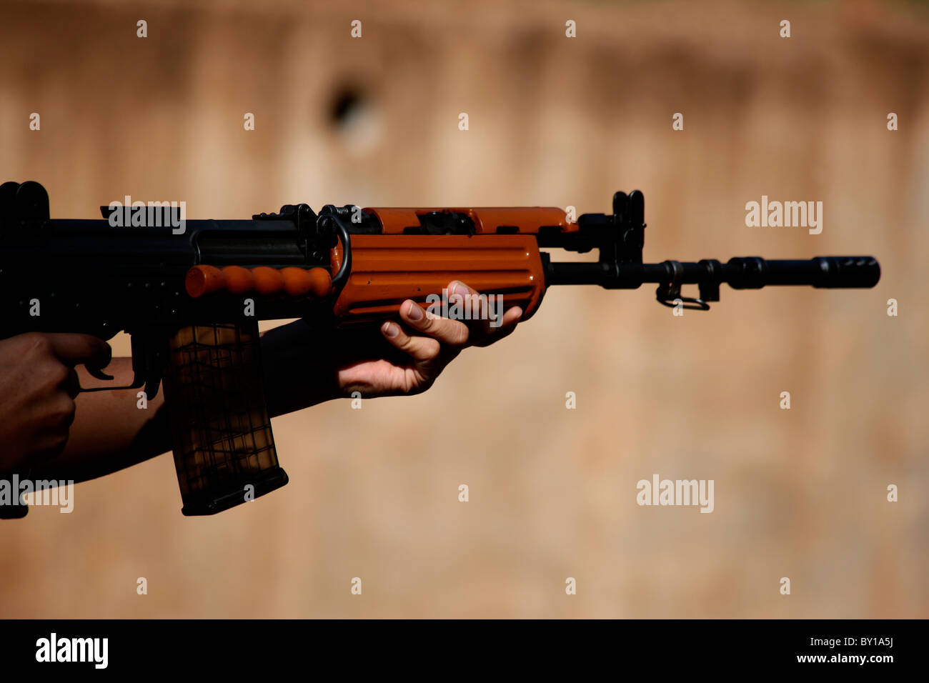 A person aiming the gun- only hand and gun is shown Stock Photo - Alamy