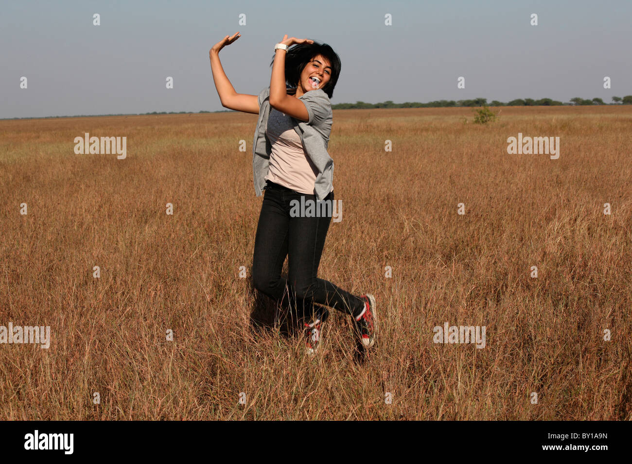 An Indian girl jumping in a grassland Stock Photo - Alamy