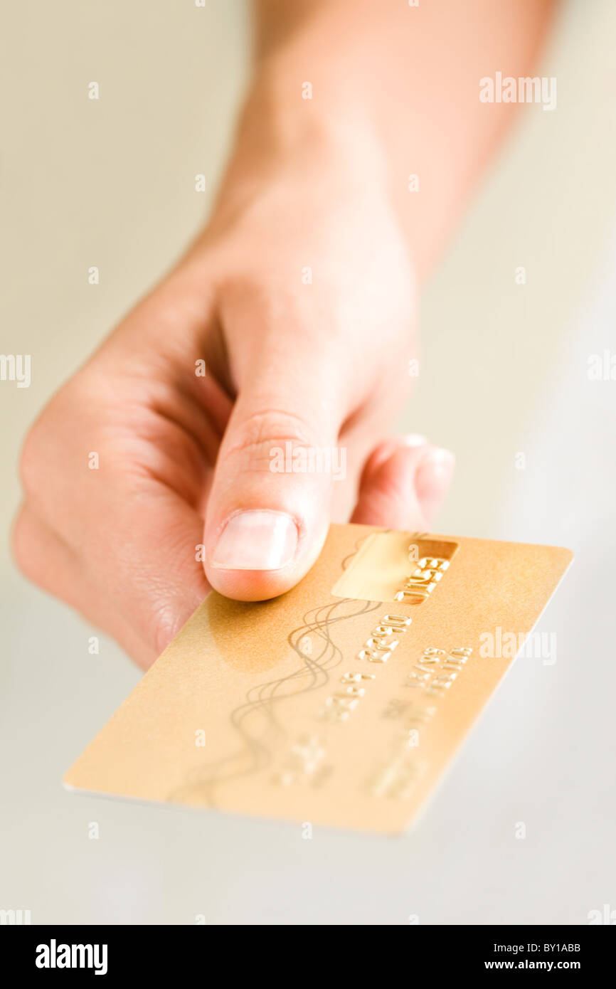 Close-up of female’s hand holding credit card and giving it to someone ...