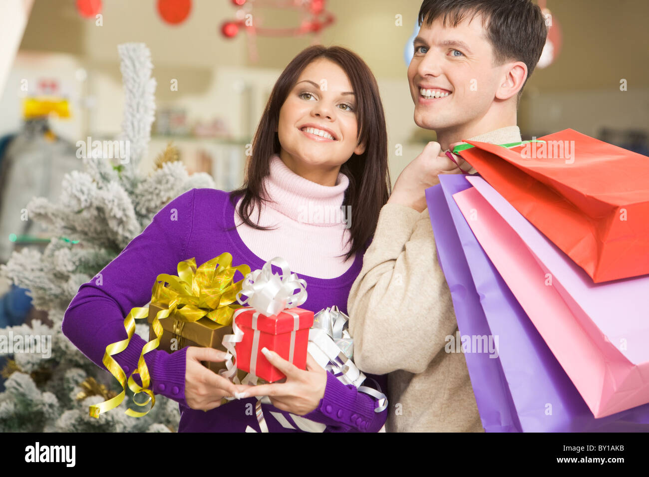 Image of attractive couple looking side and smiling in trade center ...