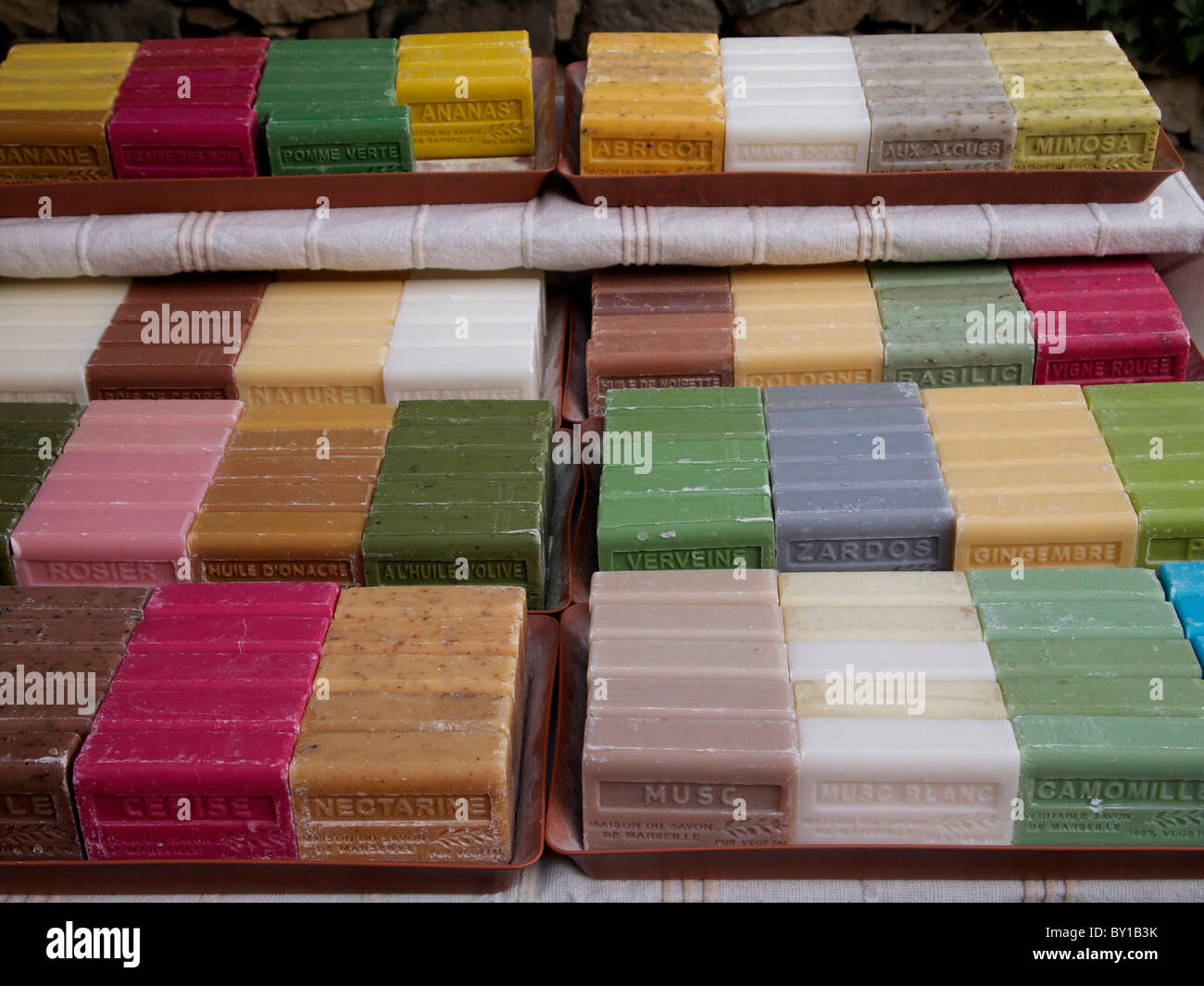 Colorful assortment of handmade soaps arranged neatly in a market stall ...