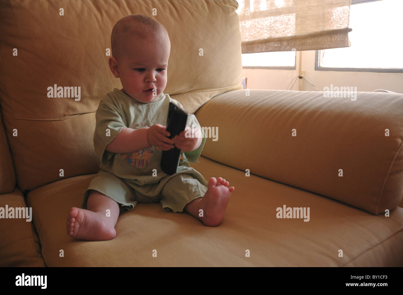 Child playing with a TV remote Stock Photo - Alamy