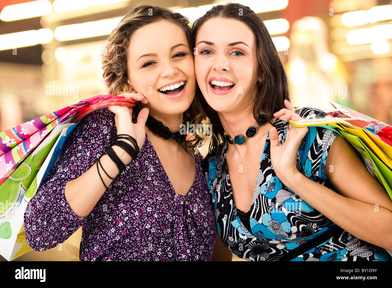 Faces of cheerful ladies in the shopping mall looking at camera amd ...