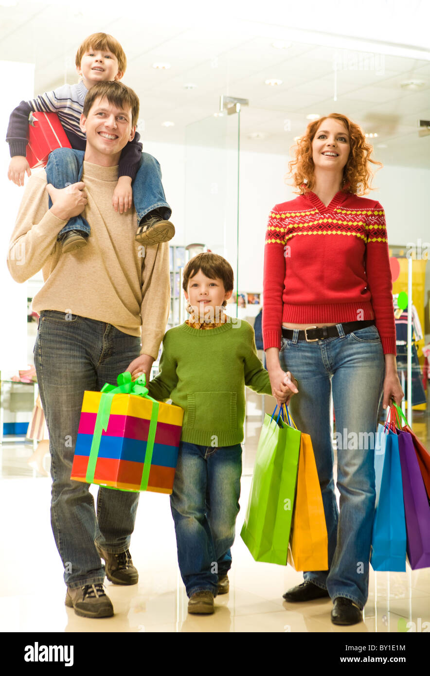 Modern family going shopping in trade center before Christmas time ...