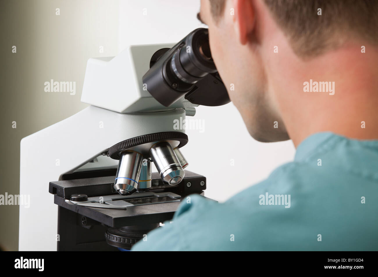 Researcher viewing through microscope hi-res stock photography and ...
