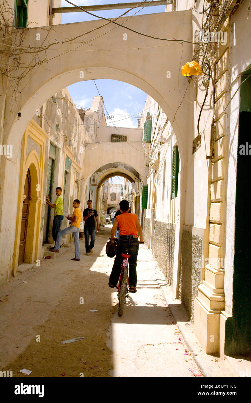 Tripoli, Libya; A youth riding a bicycle in the streets of the old ...