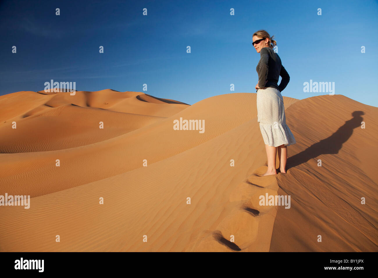Oman, Empty Quarter. Oman, Empty Quarter. A young lady standing at the ...