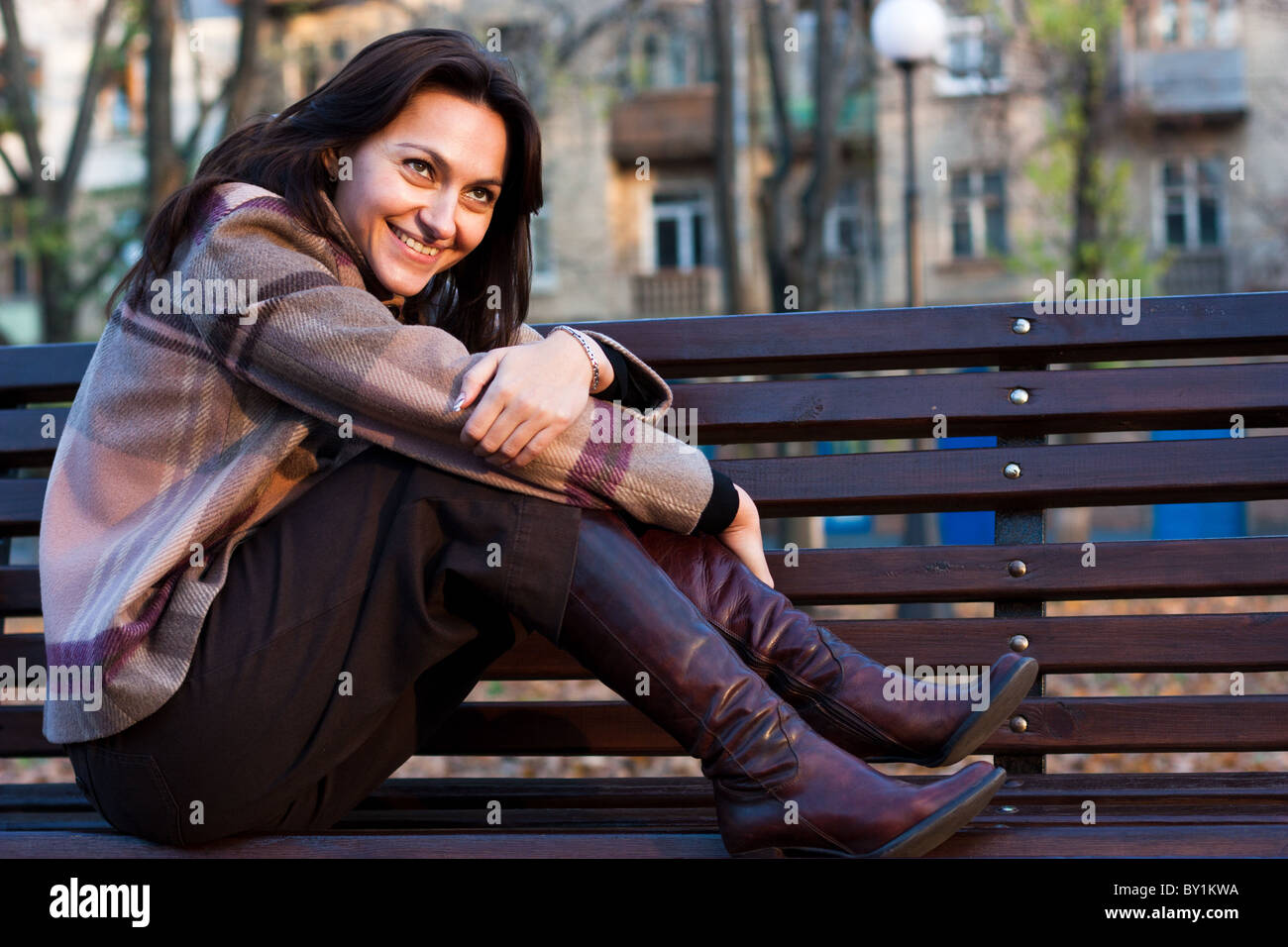 Beautiful young woman on a bench in autumn Stock Photo - Alamy
