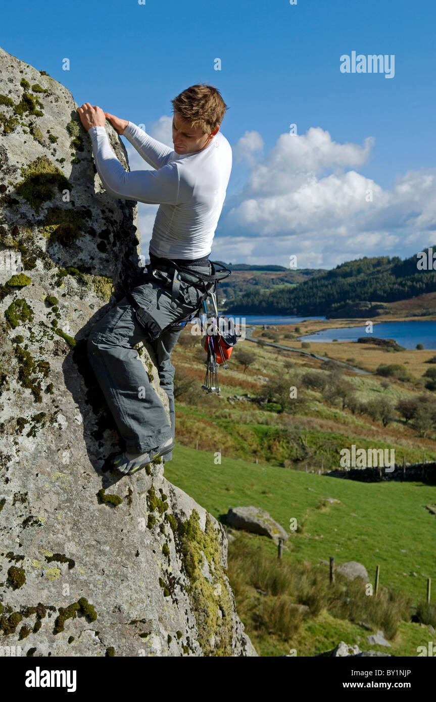 UK, North Wales, Snowdonia. A man rock climbing on a large granite ...