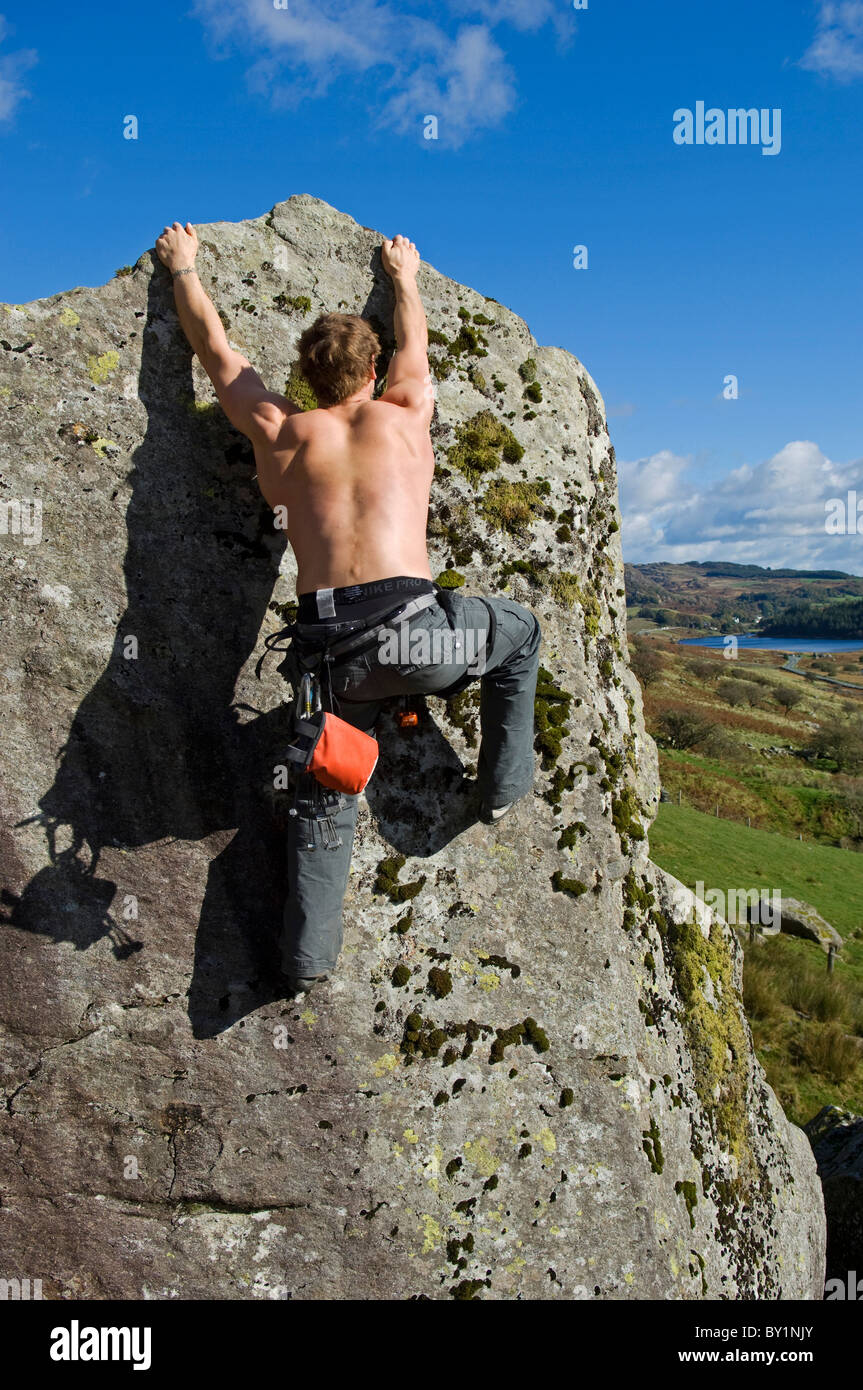 UK, North Wales, Snowdonia. A man rock climbing on a large granite ...