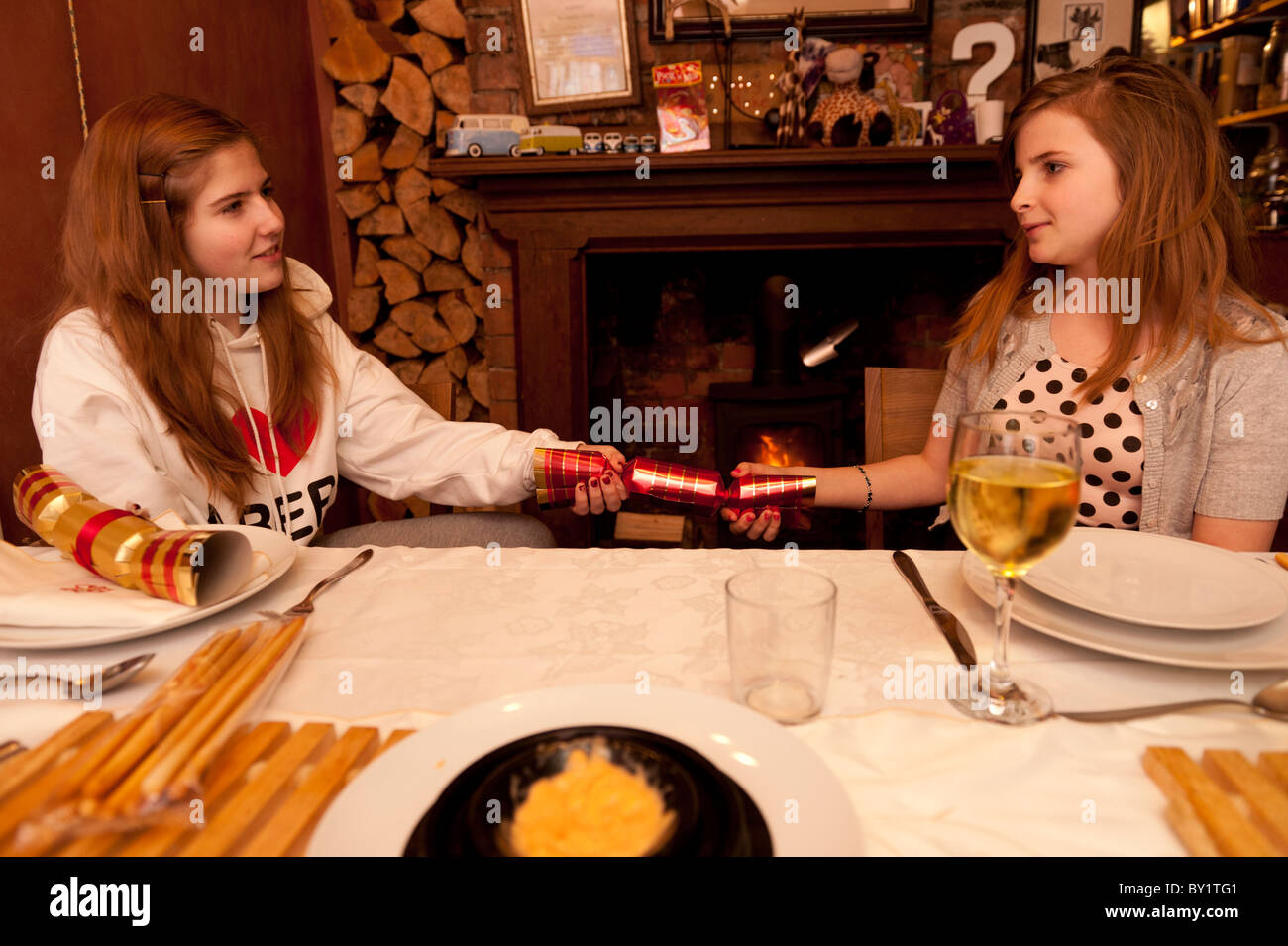 Two sisters pulling a cracker - A traditional British family christmas ...