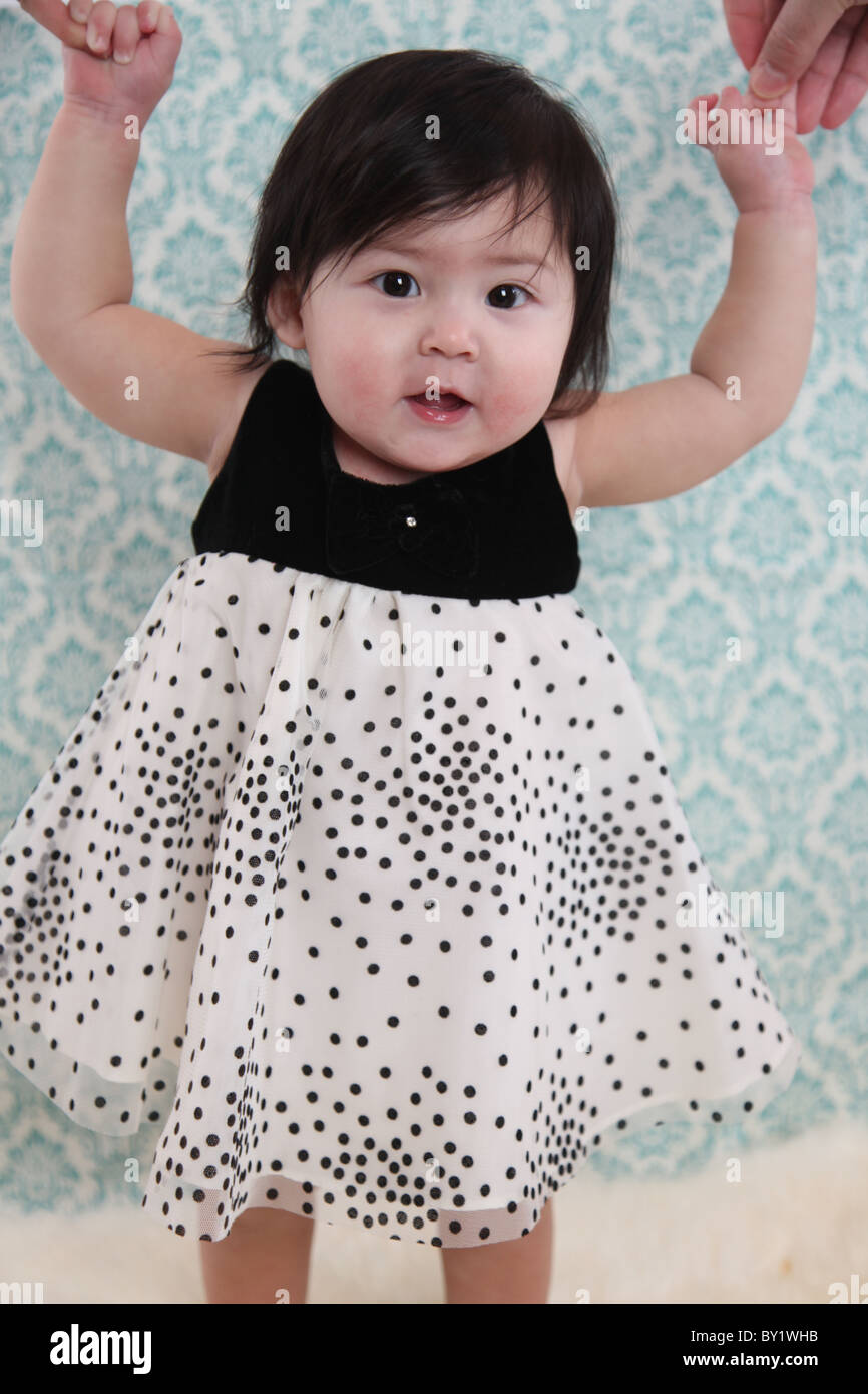 Cute Asian baby standing, holding parents hands Stock Photo - Alamy