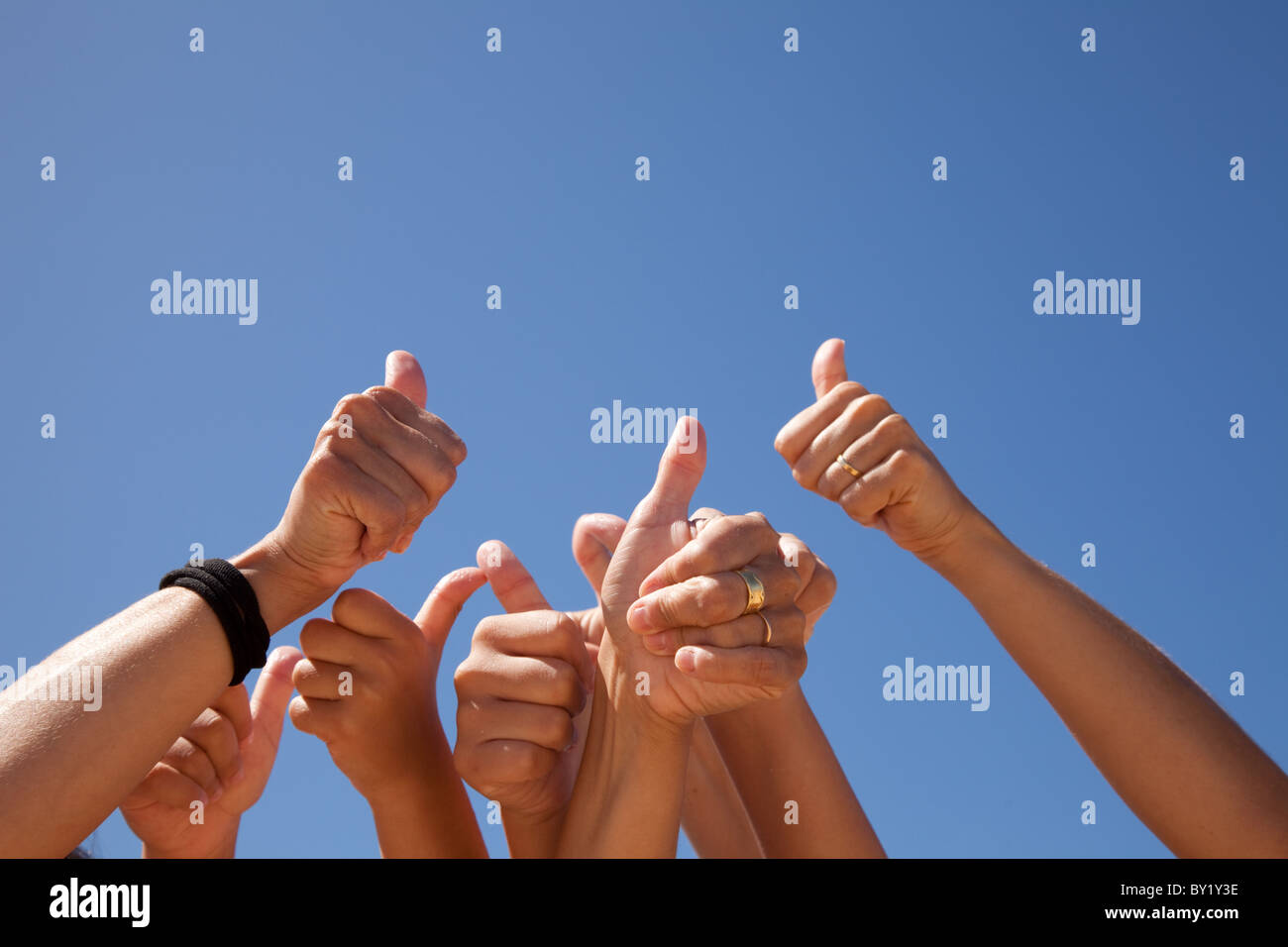 many hands raised to the blue sky (some motion blur Stock Photo - Alamy