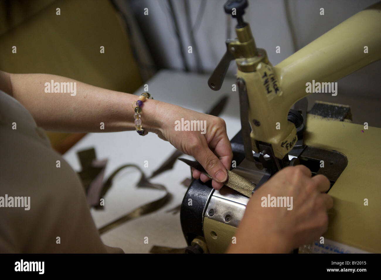A shoemaker works on a pair of shoes in fashion designer Jimmy Choo's ...