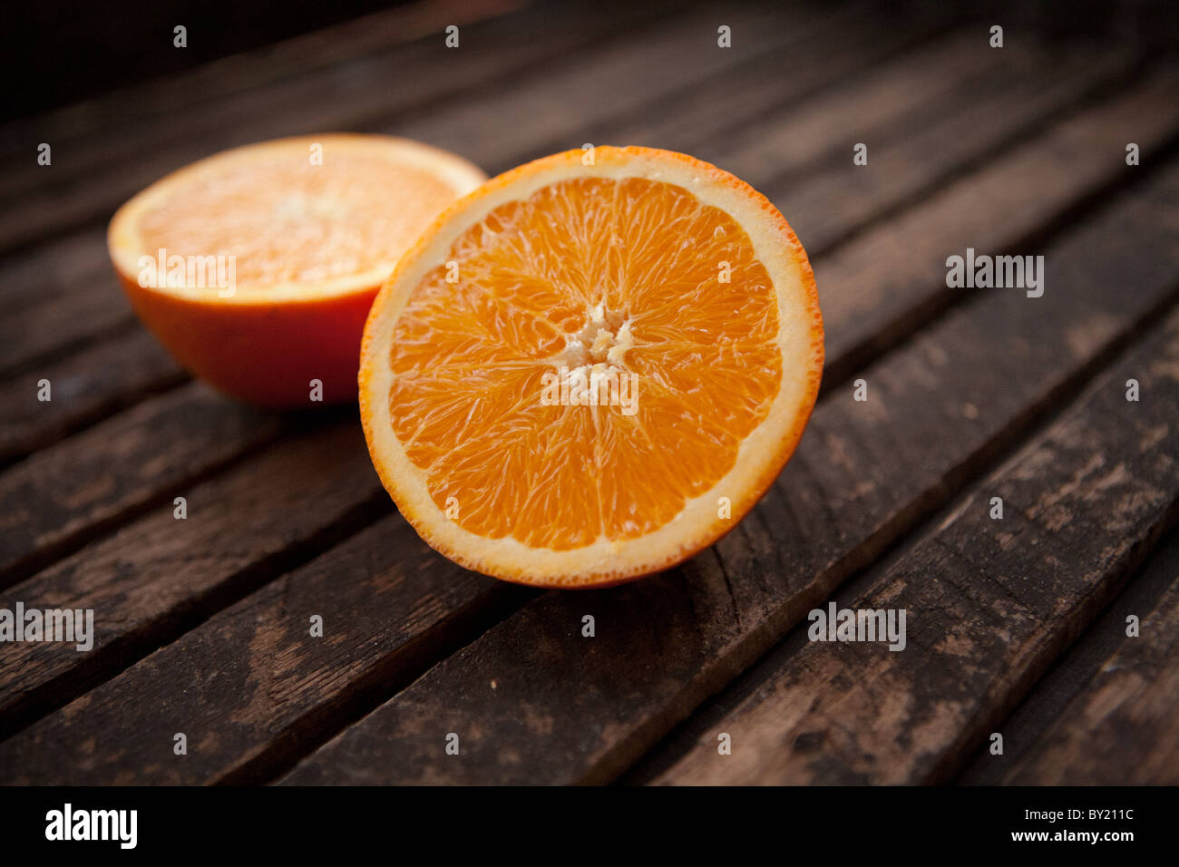 Two orange halves on a wooden surface Stock Photo - Alamy