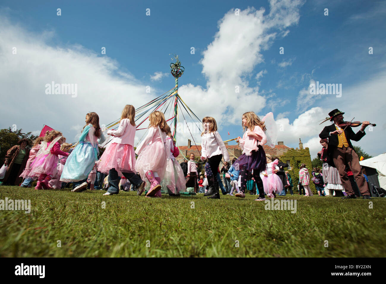 Norfolk, Holt Hall. Children dressed as fairies dance around a maypole ...