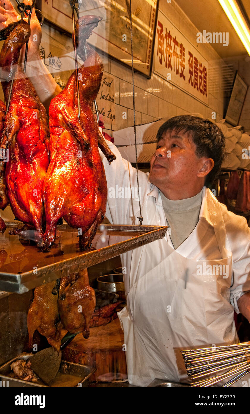 Chinese man arranging Peking Duck in window in Chinatown San Francisco ...