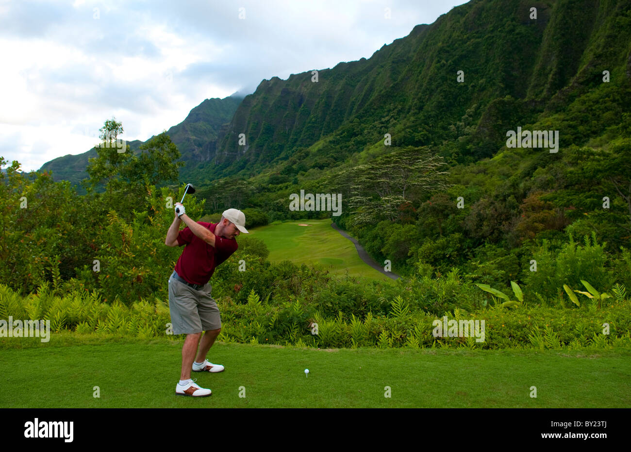 Golfer driving from beautiful elevated 15th hole of famous Ko'olau Golf ...