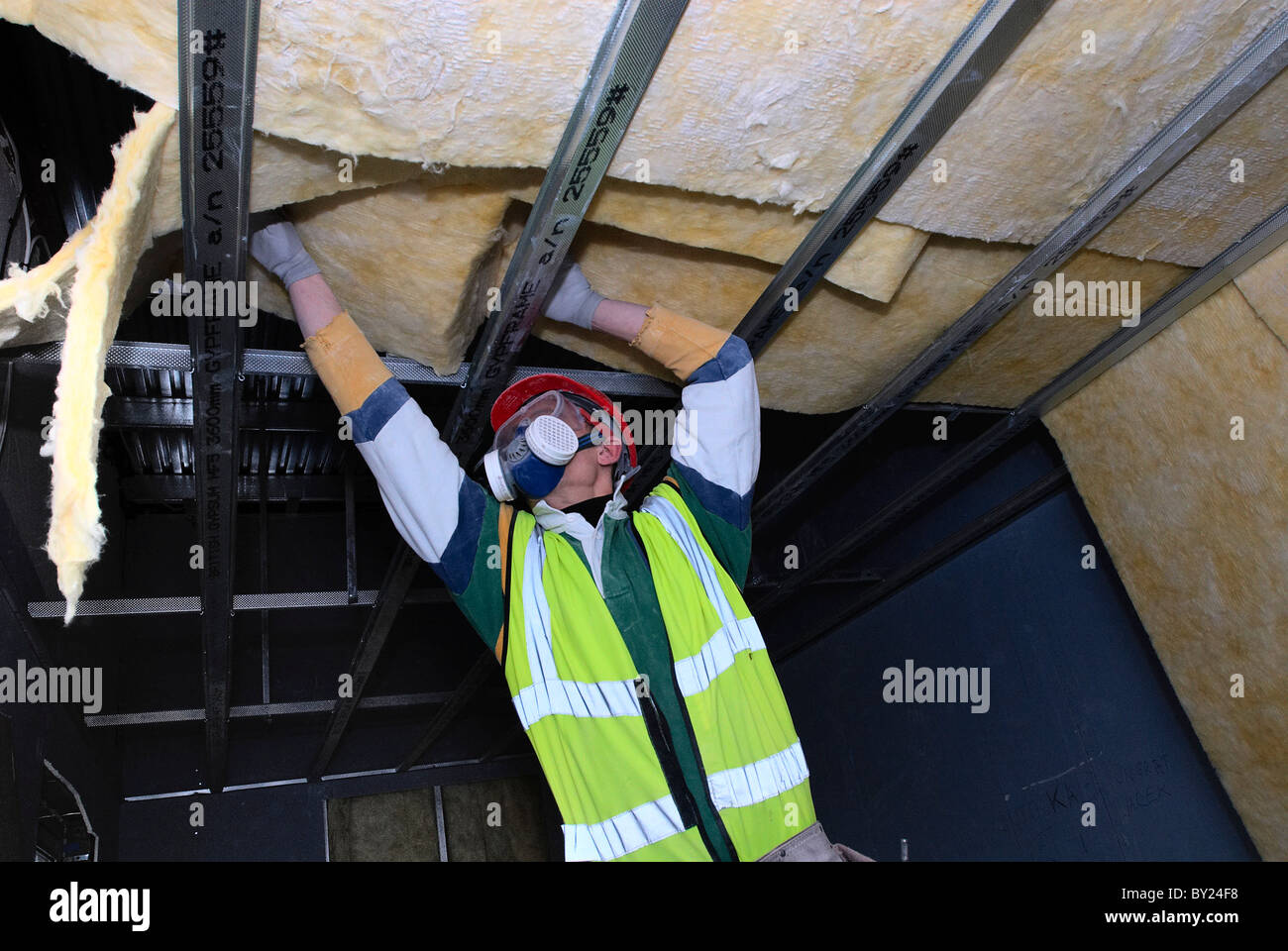 Builder fitting insulation fiberglass panels Stock Photo - Alamy