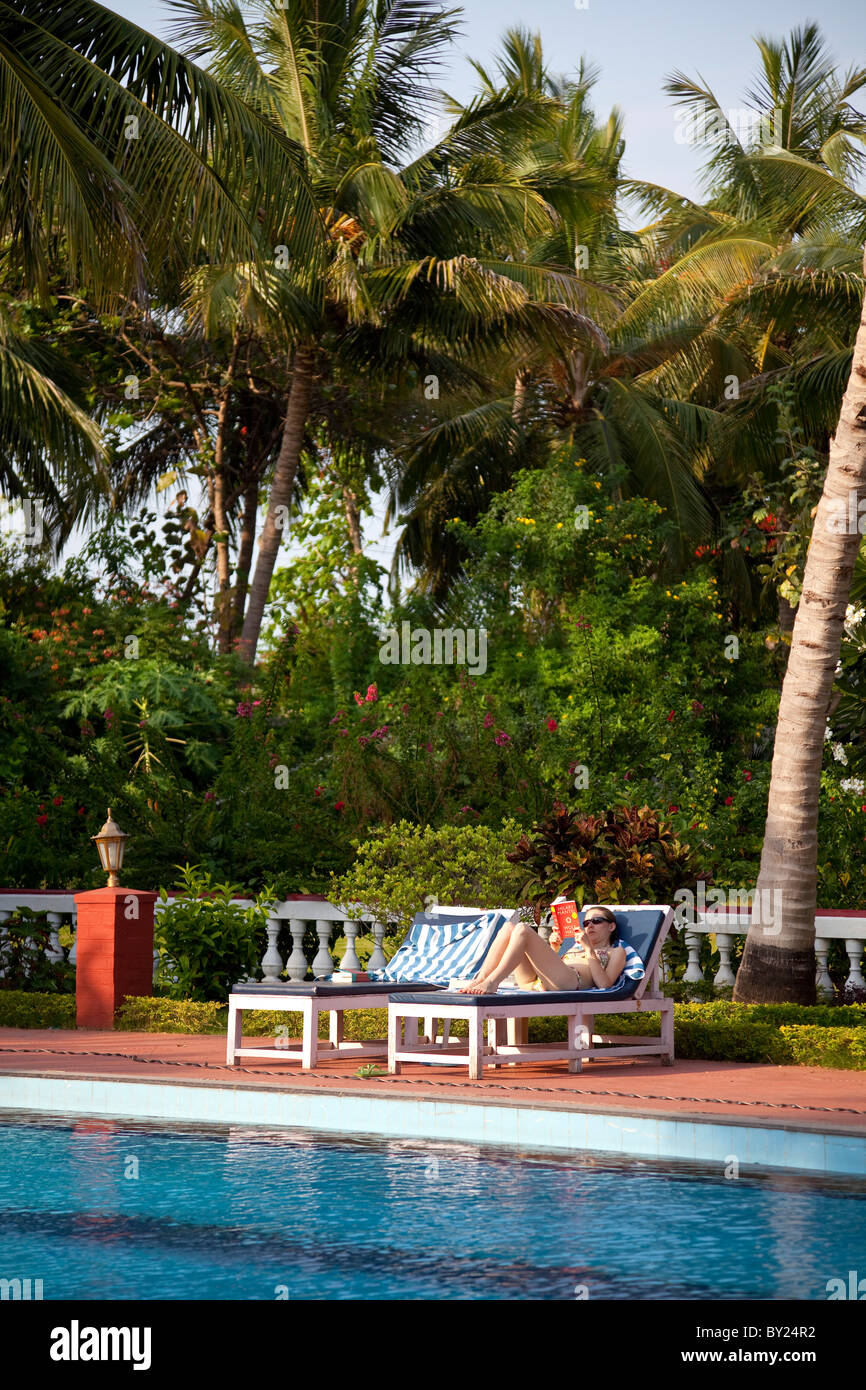 India, Thanjavur. A tourist lazes by the pool at the Ideal Beach Resort ...