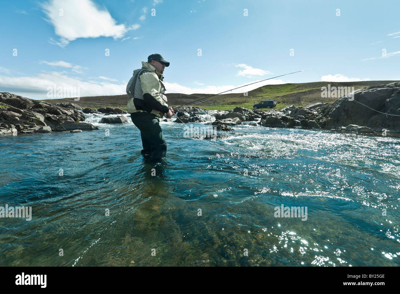 Fly fisherman casting the fly in beautiful surroundings in Iceland ...