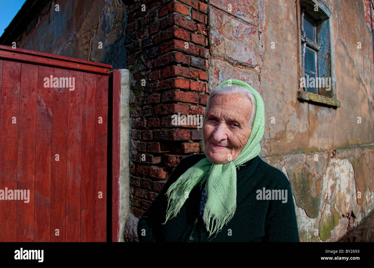 Portrait older woman in front of house in small village in Poznan ...
