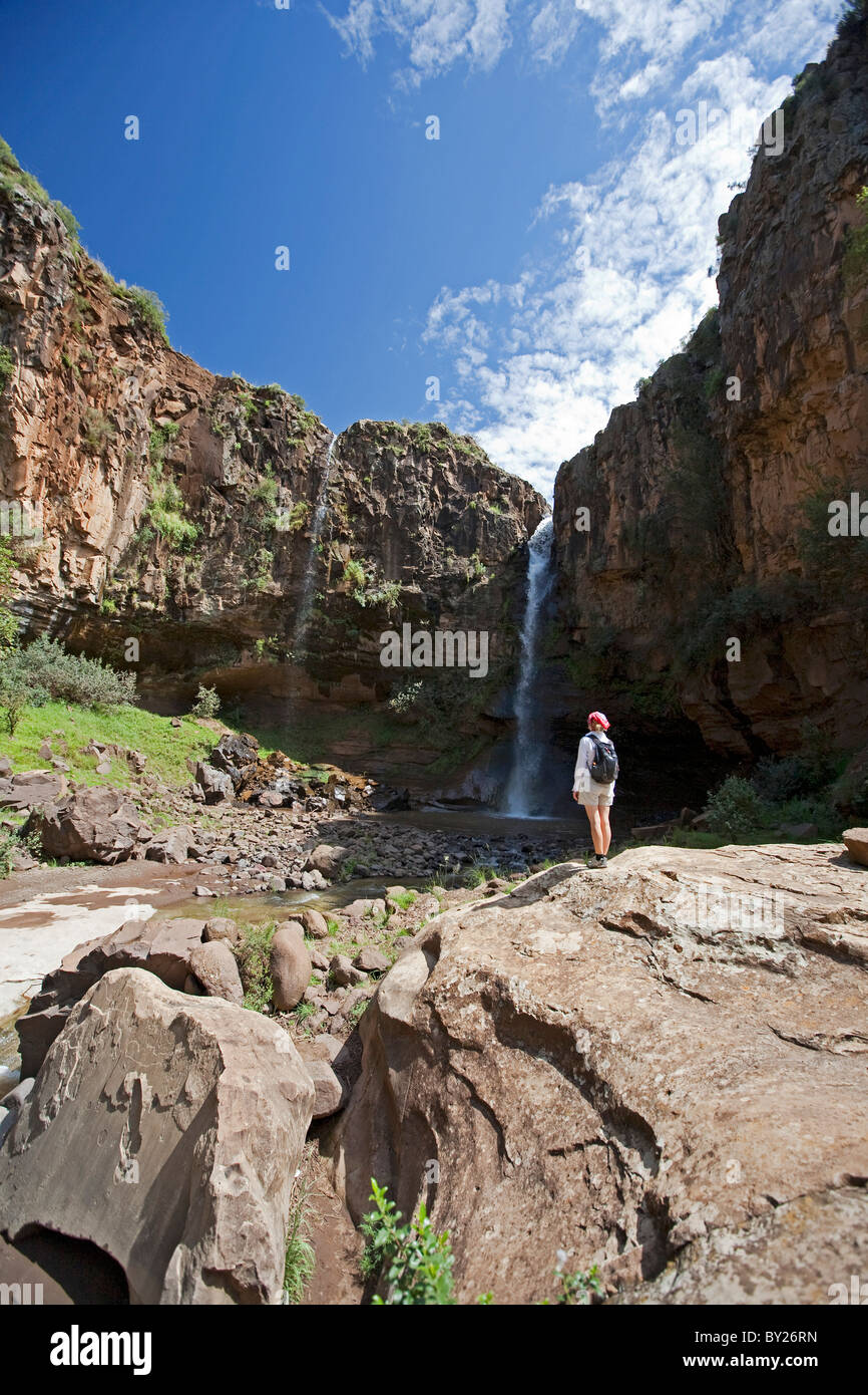 Lesotho, Malealea. A tourist looks at a waterfall whilst on a trek from ...