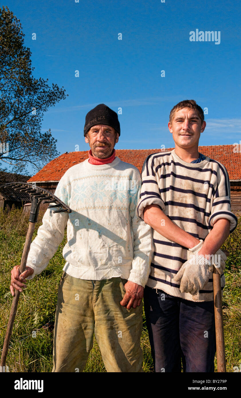 Poor simple father son farmers working in farm in Marijampole in ...