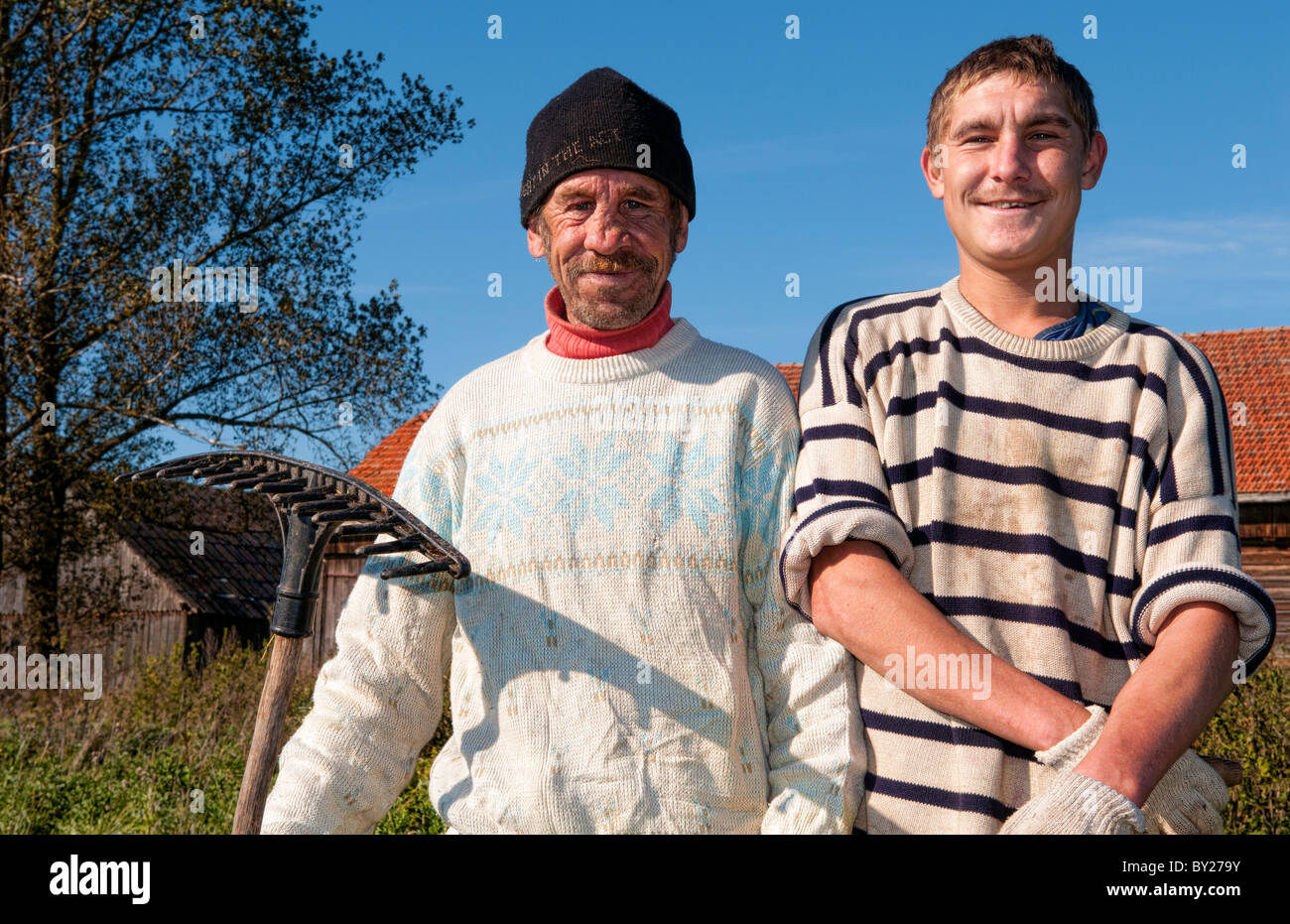 Poor simple father son farmers working in farm in Marijampole in ...