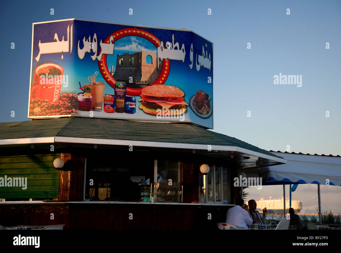 Tripoli, Libya; A kiosk with a huge advert, facing the Tripoli port ...