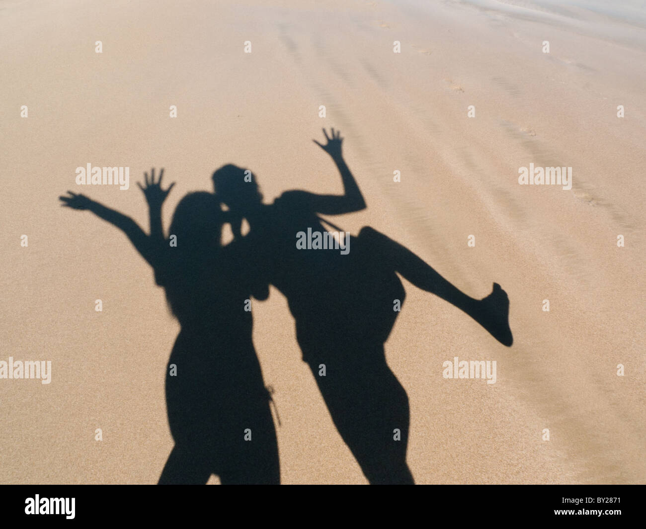 young couple playing with shadow on sand Stock Photo - Alamy