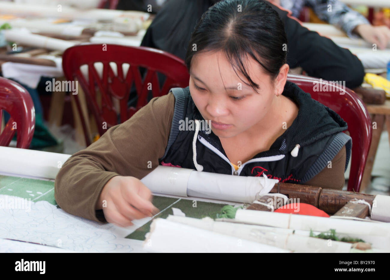 Woman sewing factory labor work making tedious handmade items in Hanoi ...