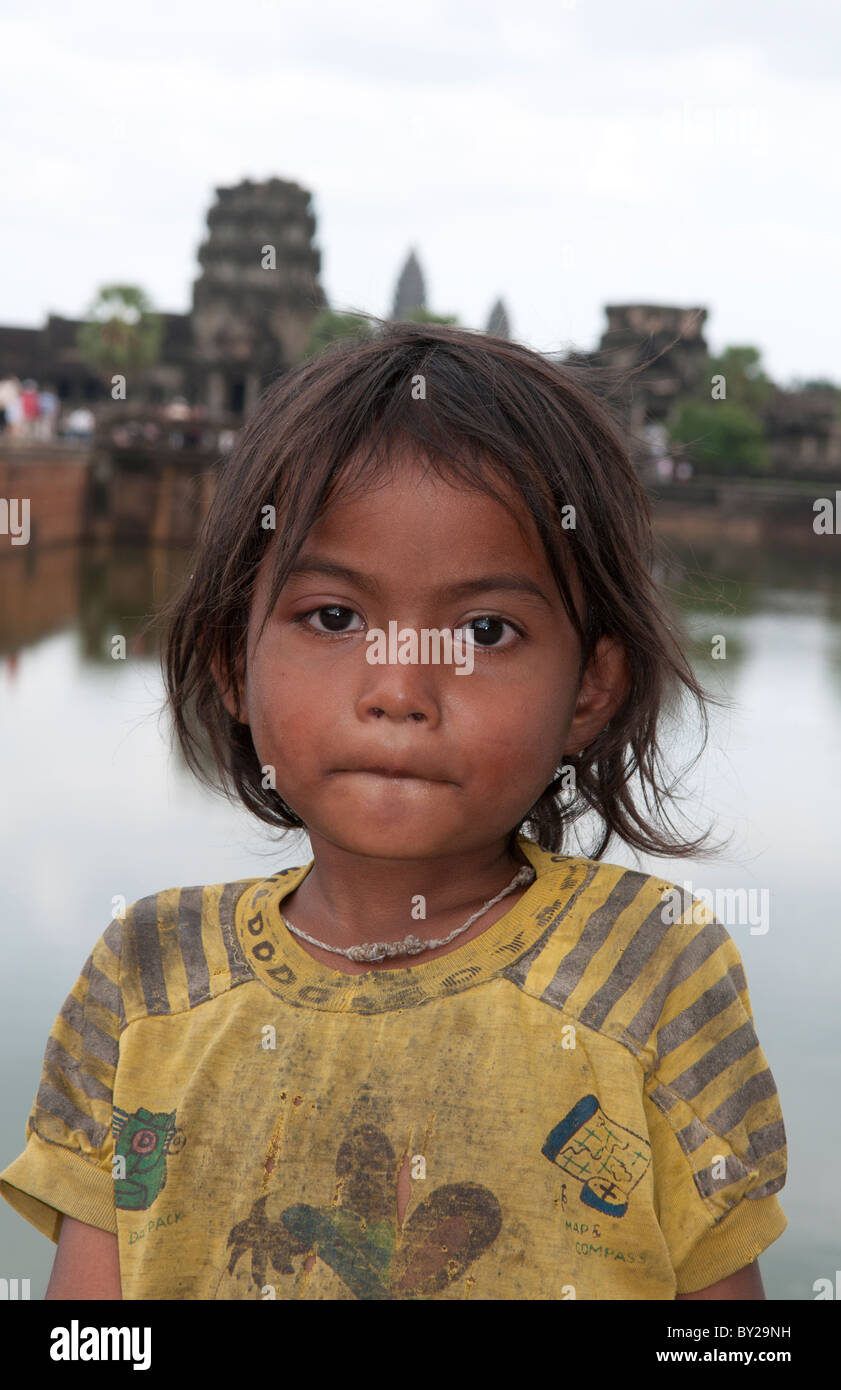 Young poor girl aged 4 in front of river at famous Angkor Wat in Siem ...