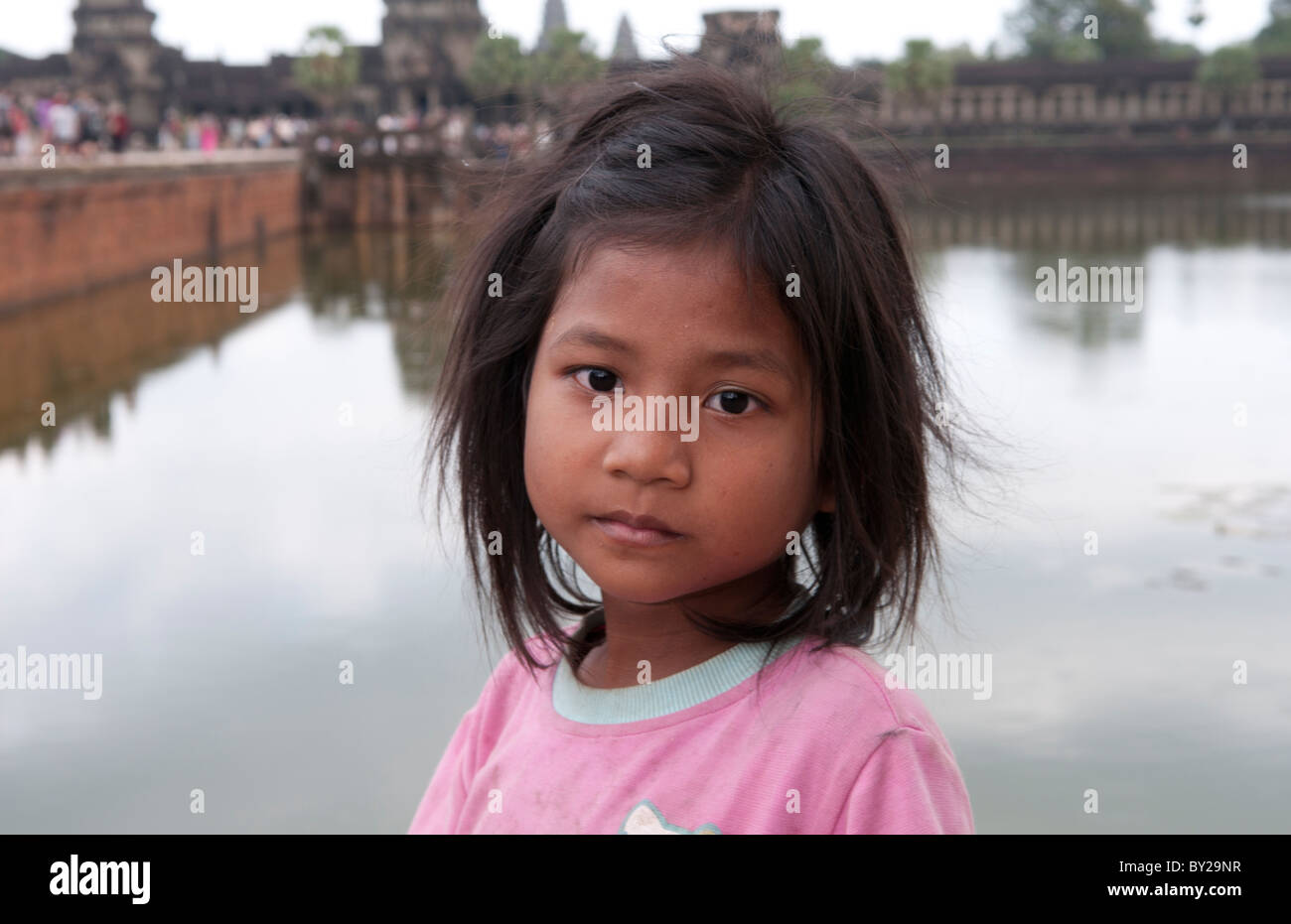 Young Poor Girl Aged 4 In Front Of River At Famous Angkor Wat In Siem Reap Cambodia In Asia
