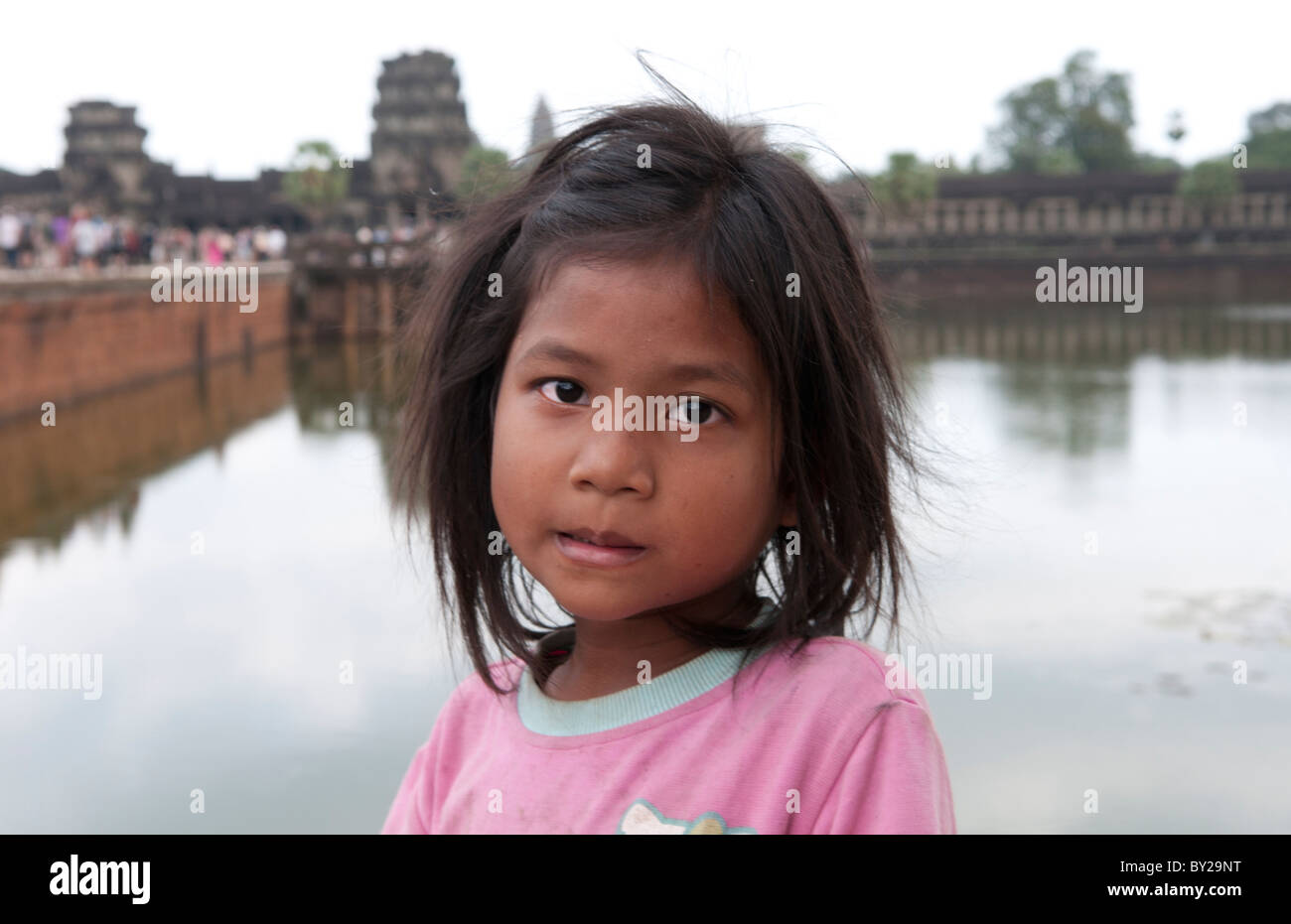 Young Poor Girl Aged 4 In Front Of River At Famous Angkor Wat In Siem Reap Cambodia In Asia