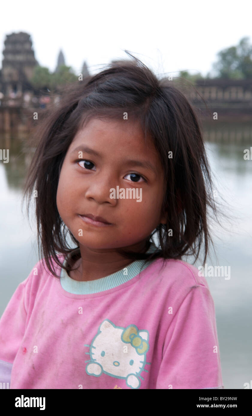 Young poor girl aged 4 in front of river at famous Angkor Wat in Siem ...