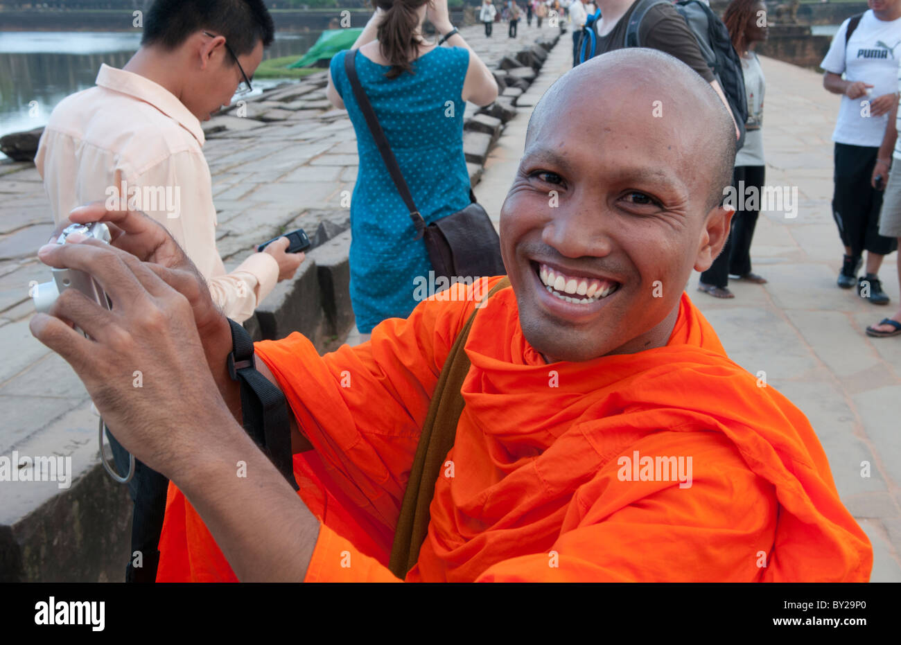 Young boy monk playing with camera and smile having fun at river at ...