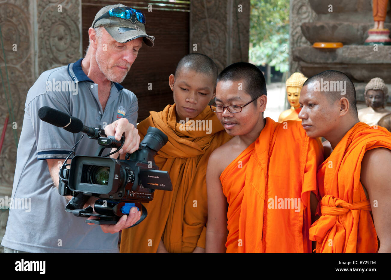 Young boy monks laughing having fun looking TV video photographer Siem ...