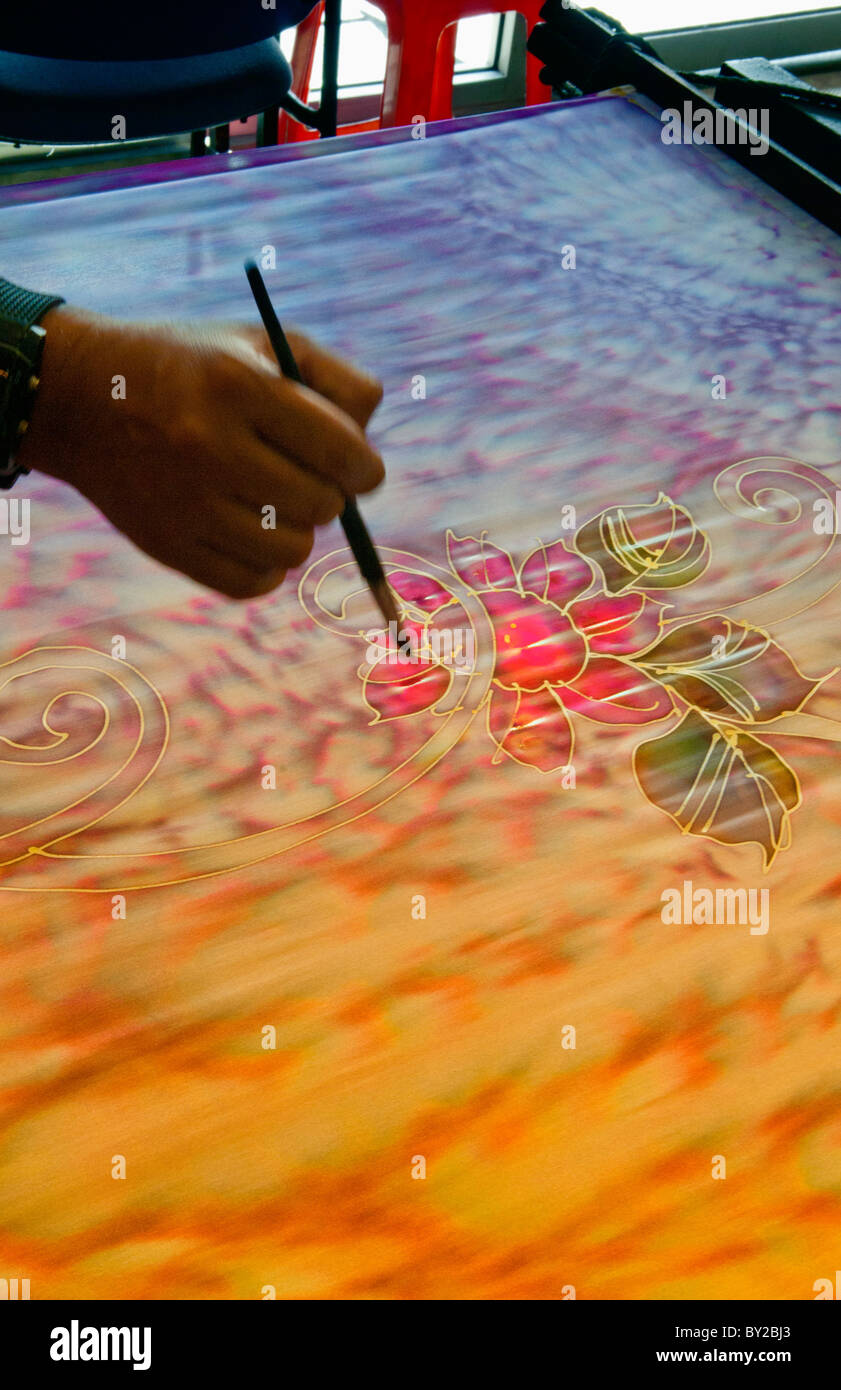 Artist painting Batik Design paint artwork on silk factory in Kuala ...