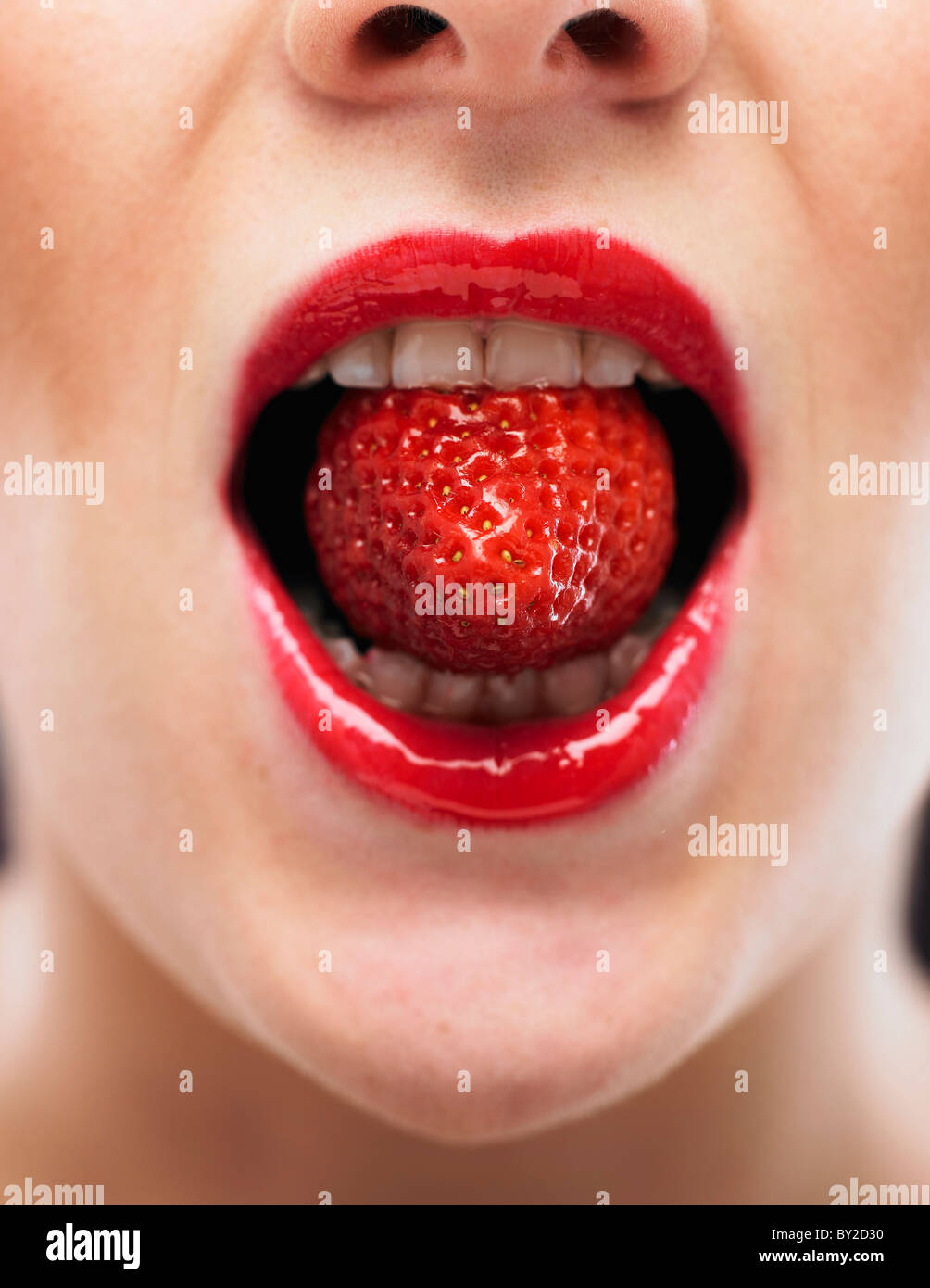 white woman biting on a stawberry Stock Photo - Alamy