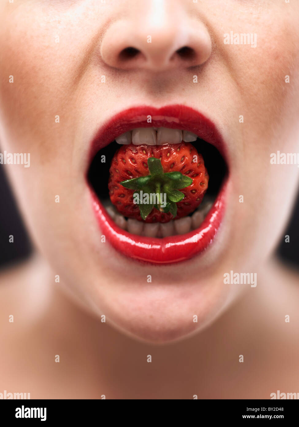 white woman biting on a stawberry Stock Photo - Alamy