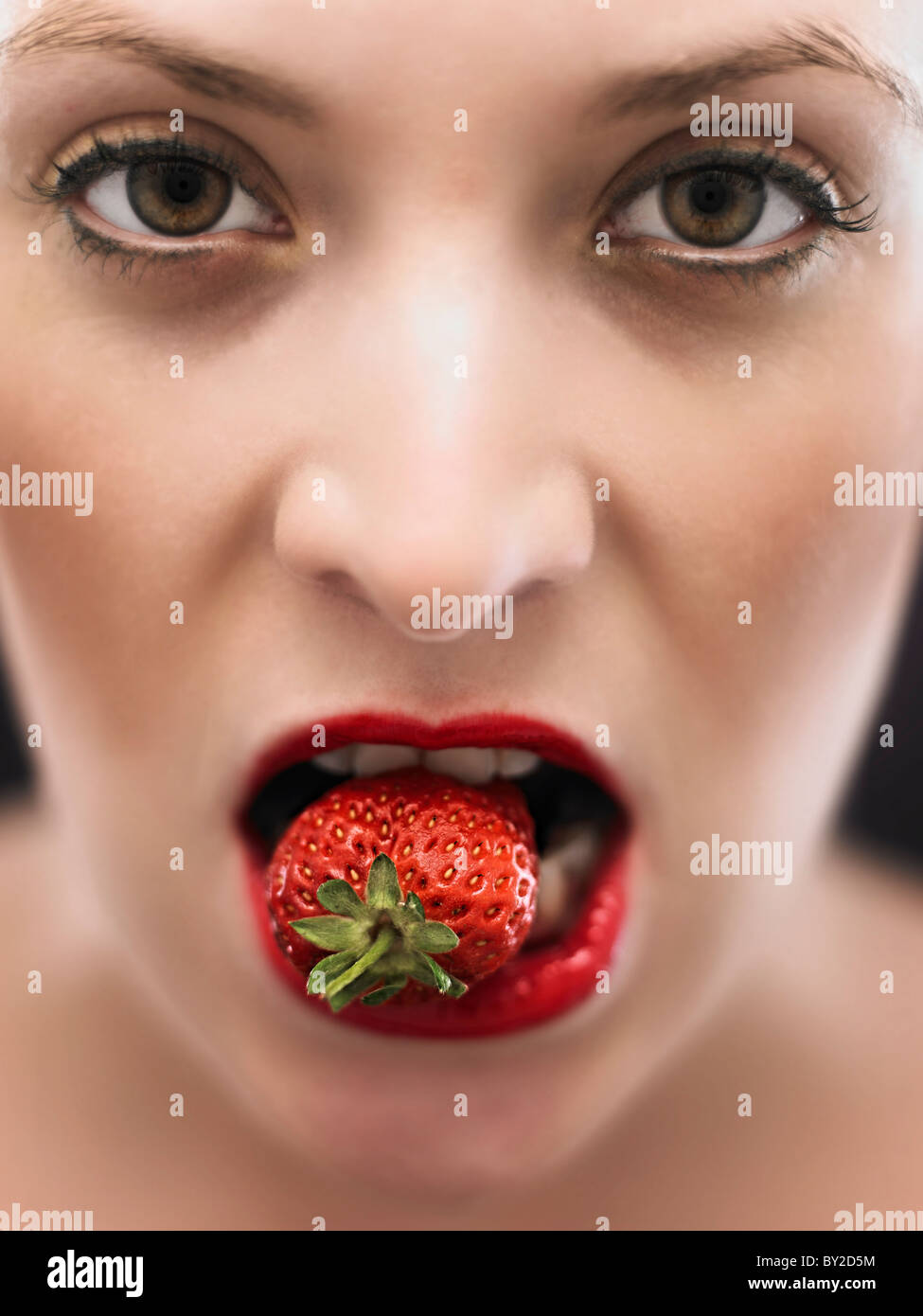white woman biting on a stawberry Stock Photo - Alamy