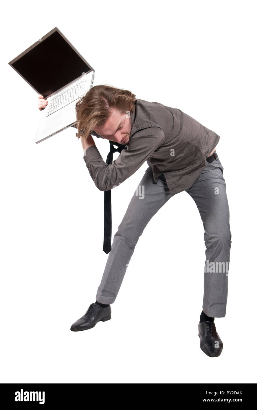 Young angry man destroys a computer. Studio photo on white background ...