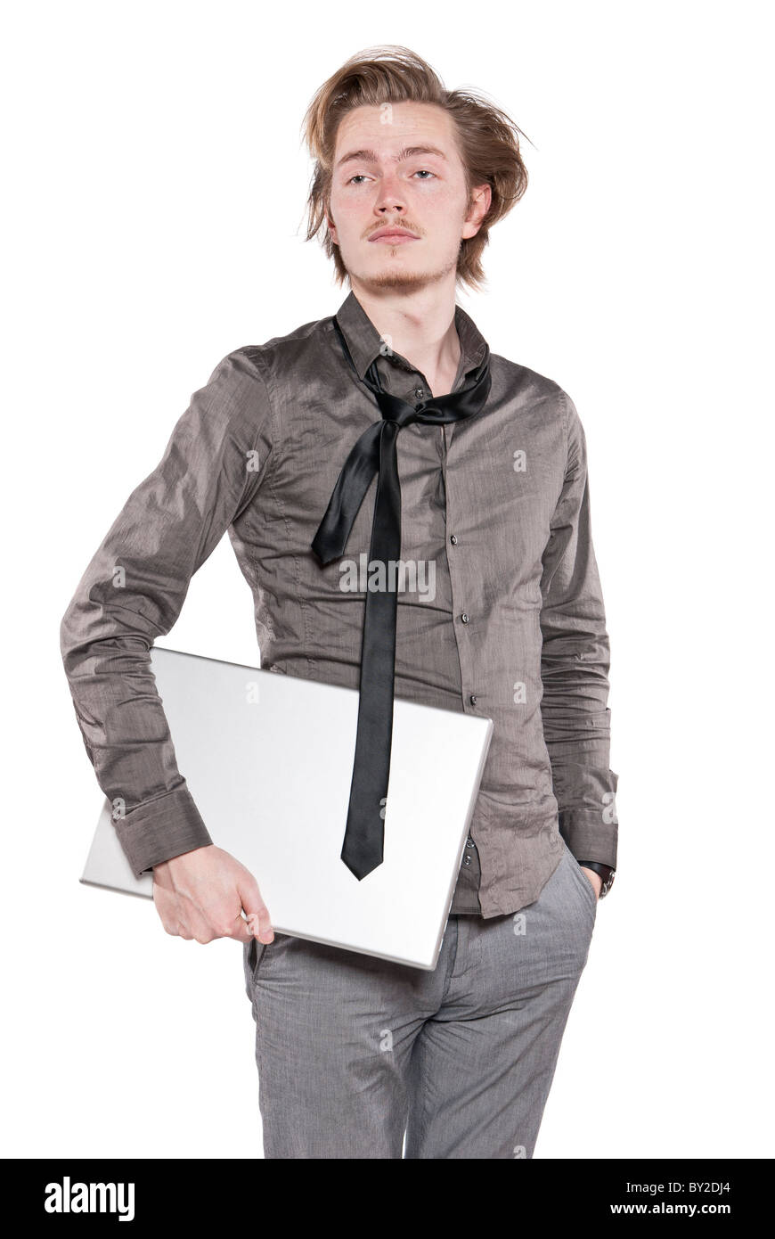 A young man stands with a computer. Studio photo on white background ...