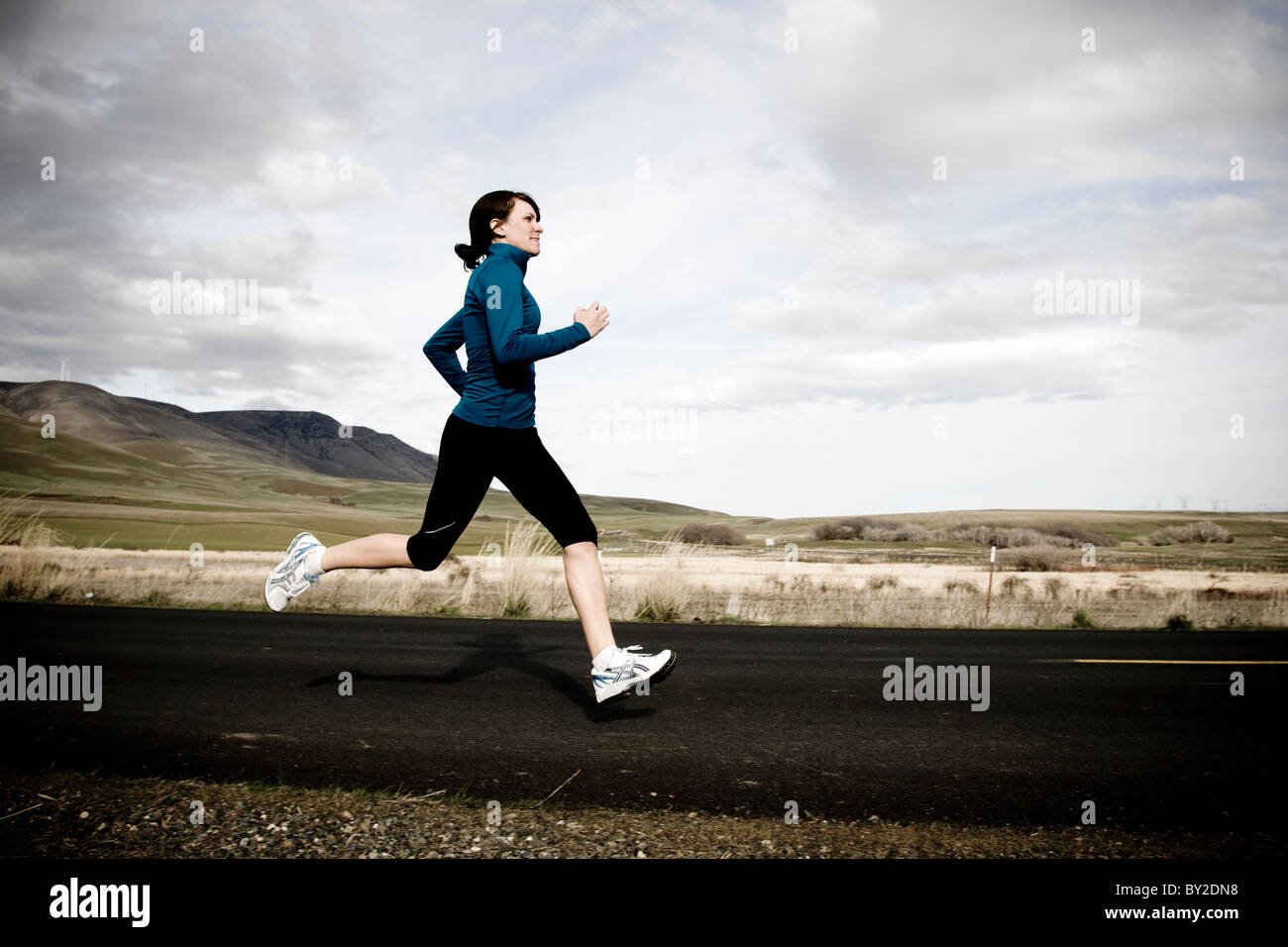 A woman out for a jog in the country Stock Photo - Alamy
