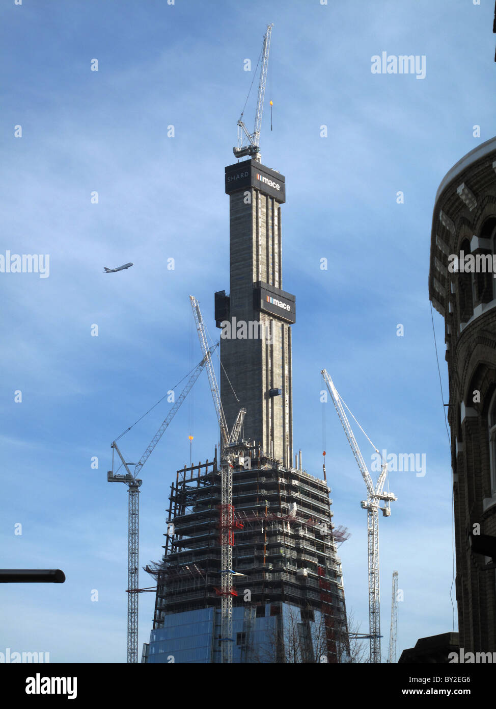 Construction of the Shard London Bridge with cranes and plane Stock ...