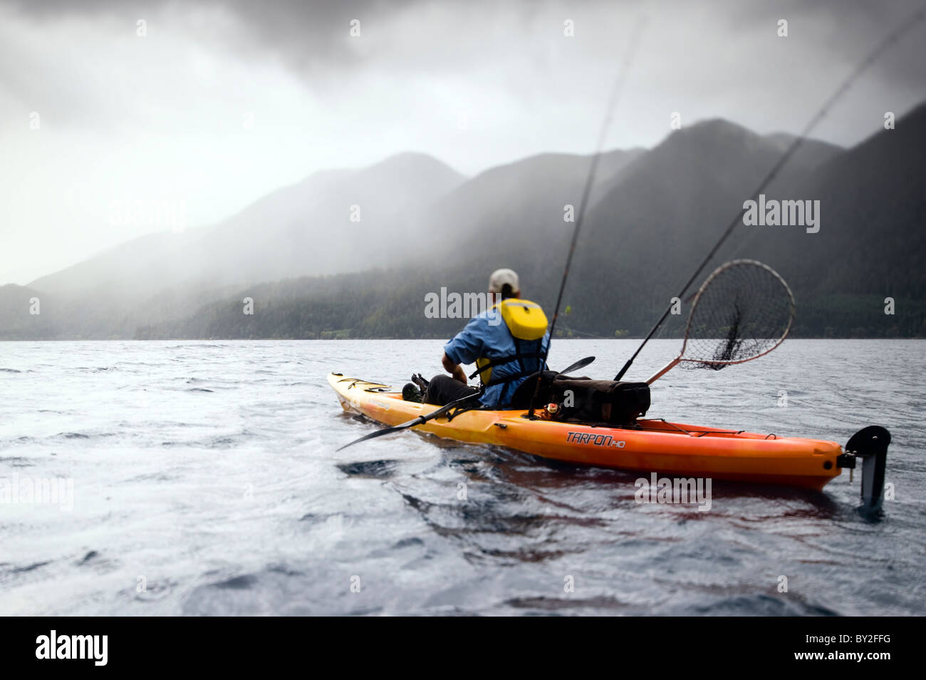 Young male fishing from a kayak on Lake Crescent Olympic National Park ...