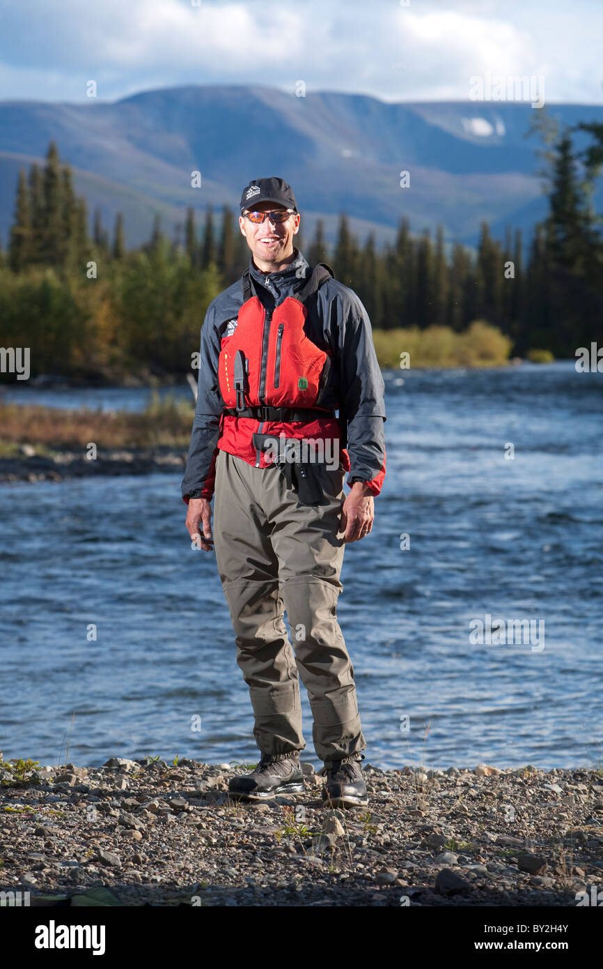 A man poses by a river in the Alaska wilderness Stock Photo - Alamy